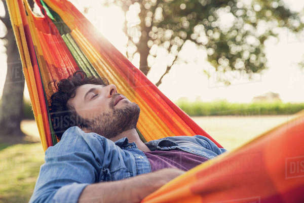 Man napping in hammock - Royalty-free Stock Photo | Dissolve