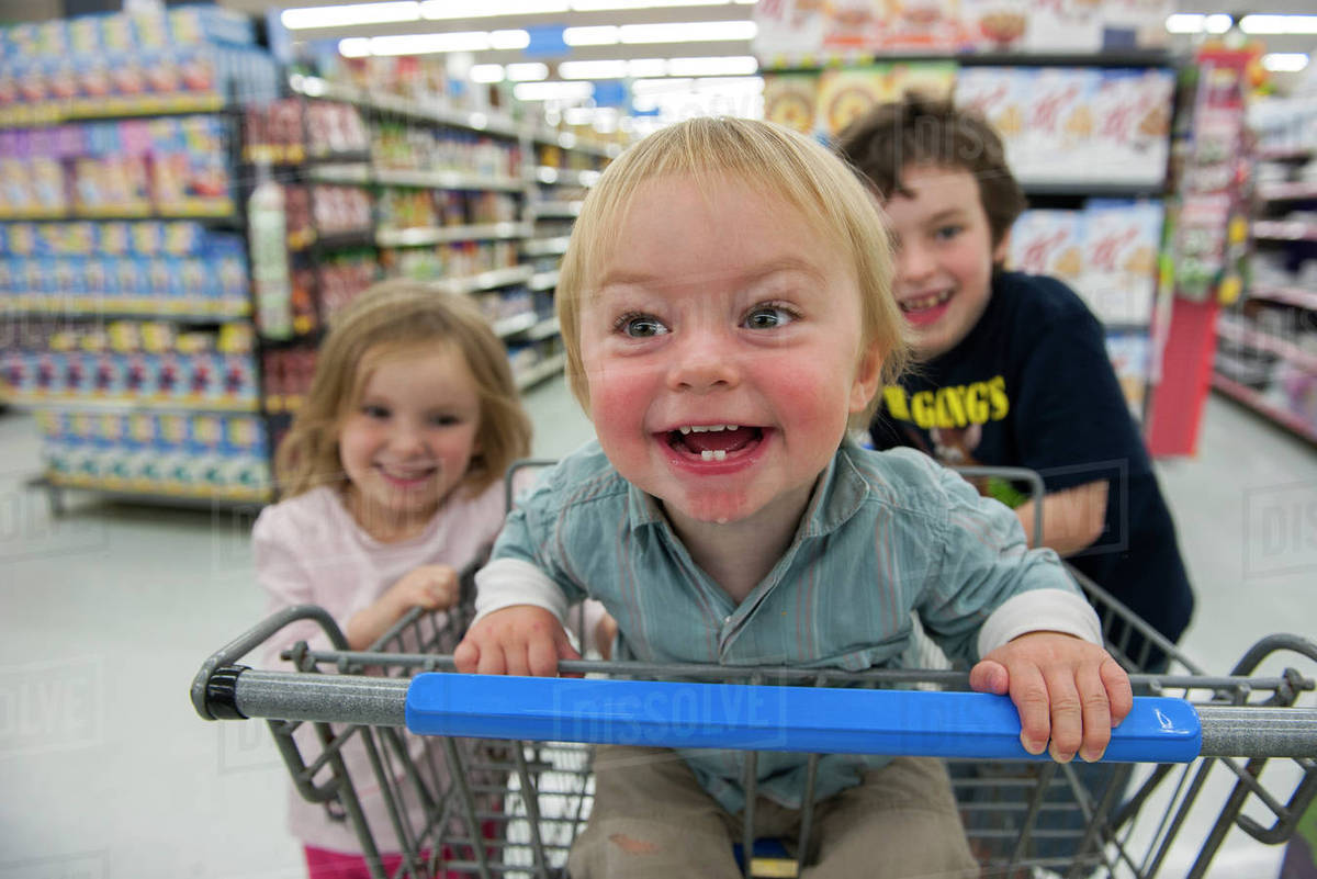 Children having fun in shopping cart - Royalty-free Stock Photo | Dissolve