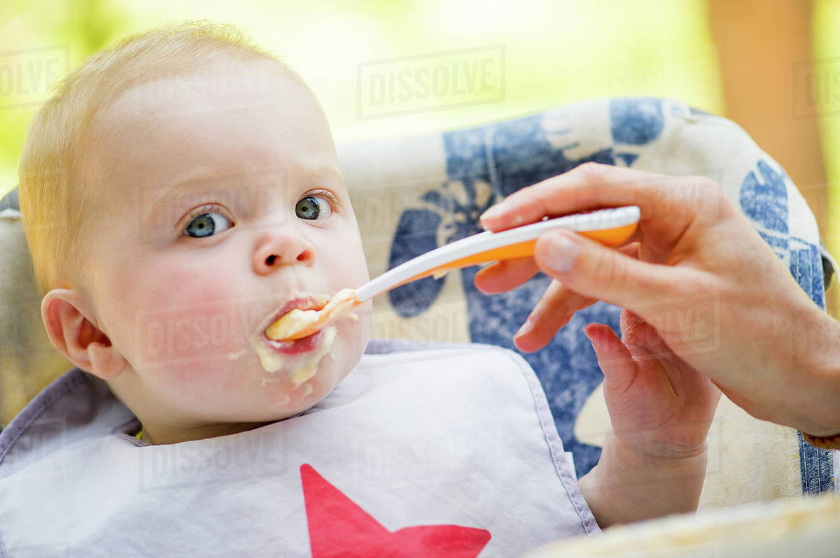 Baby being fed with spoon - Royalty-free Stock Photo | Dissolve