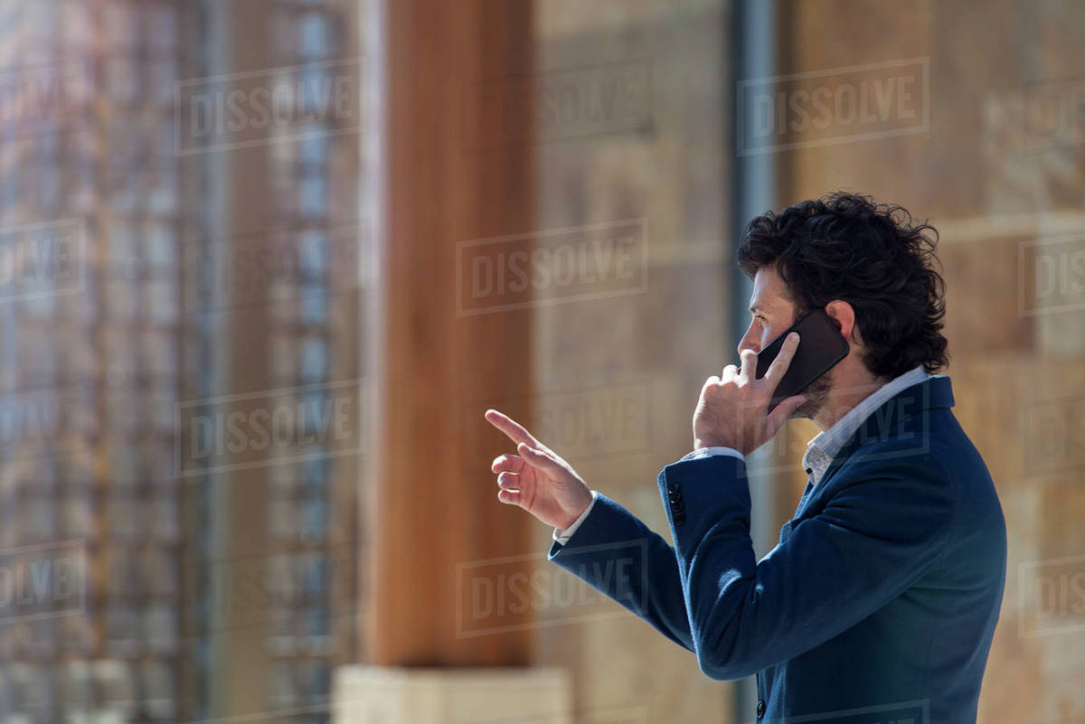 Businessman negotiating on cell phone - Stock Photo - Dissolve