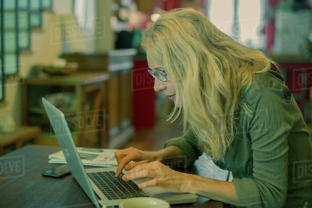 Mature woman using laptop computer at home - Royalty-free Stock Photo ...