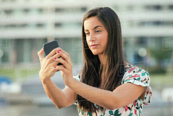 Woman taking selfie using smart phone - Stock Photo - Dissolve
