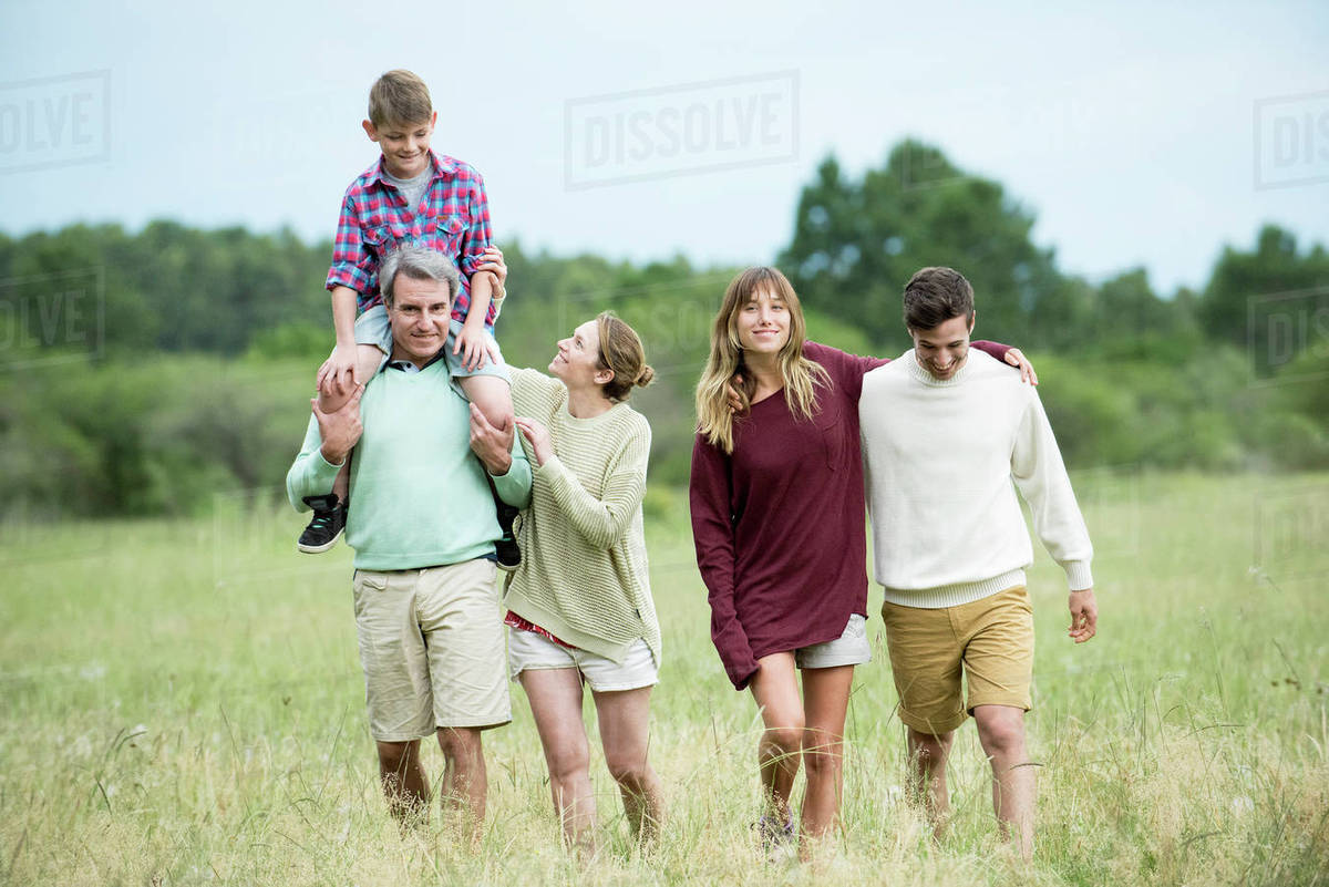 Family strolling together in field - Stock Photo - Dissolve