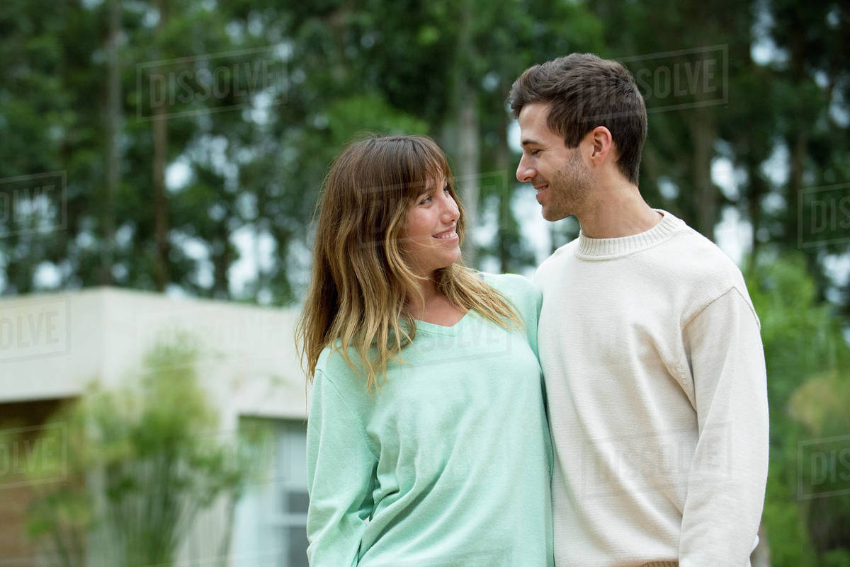 Young couple smiling at each other outdoors - Royalty-free Stock Photo ...