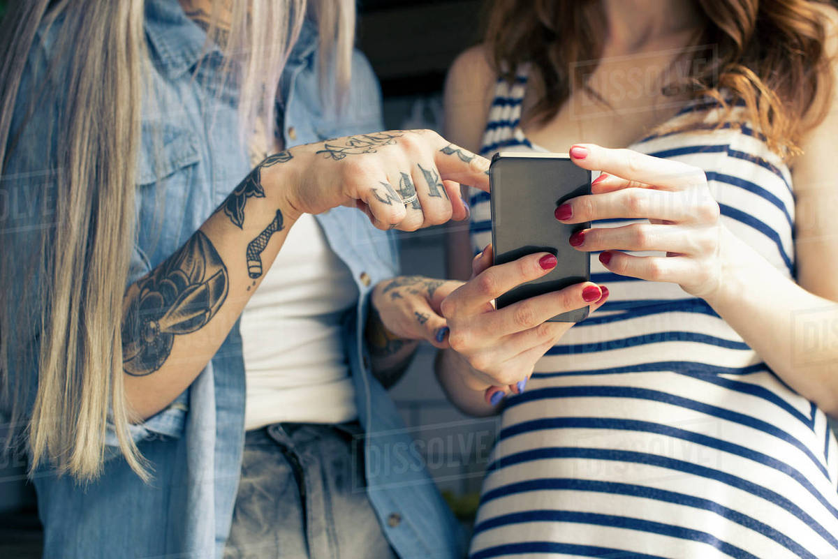 Women using smartphone together, cropped - Royalty-free Stock Photo ...