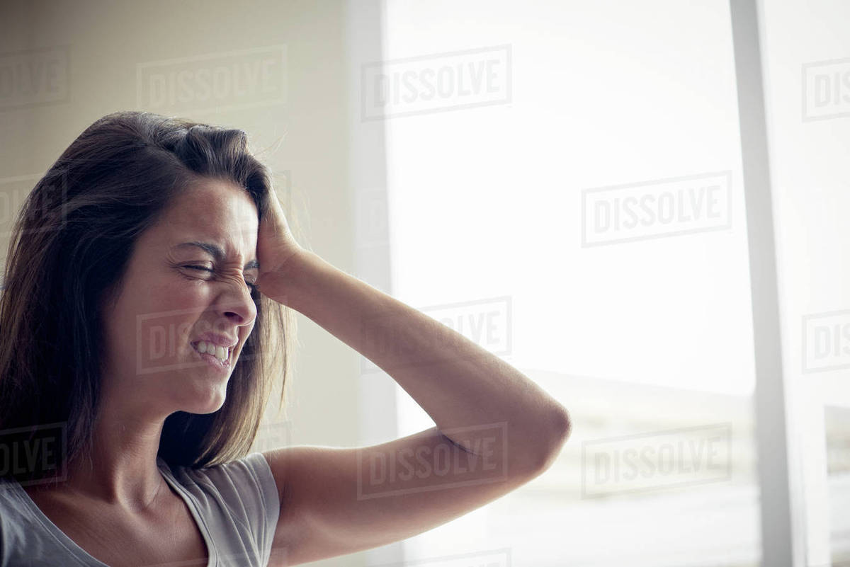 Young woman with one hand on forehead, eyes closed - Royalty-free Stock ...