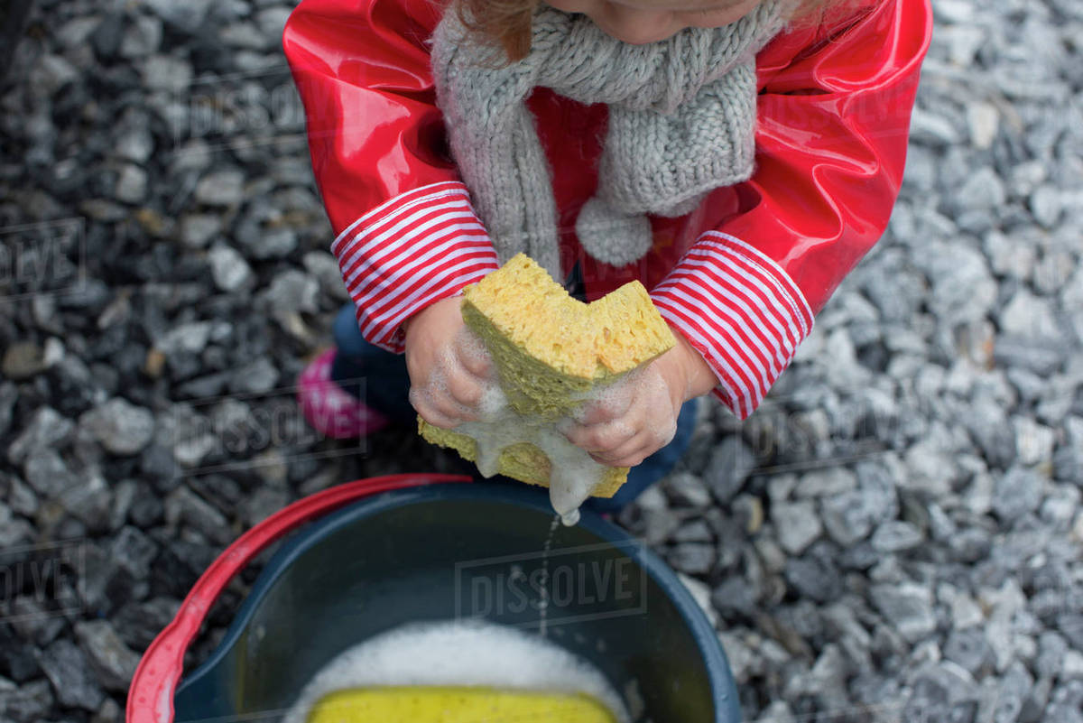 Child holding soapy sponge - Stock Photo - Dissolve