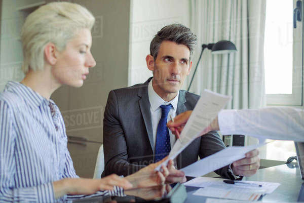 Man and woman reviewing document being explained to them - Royalty-free ...