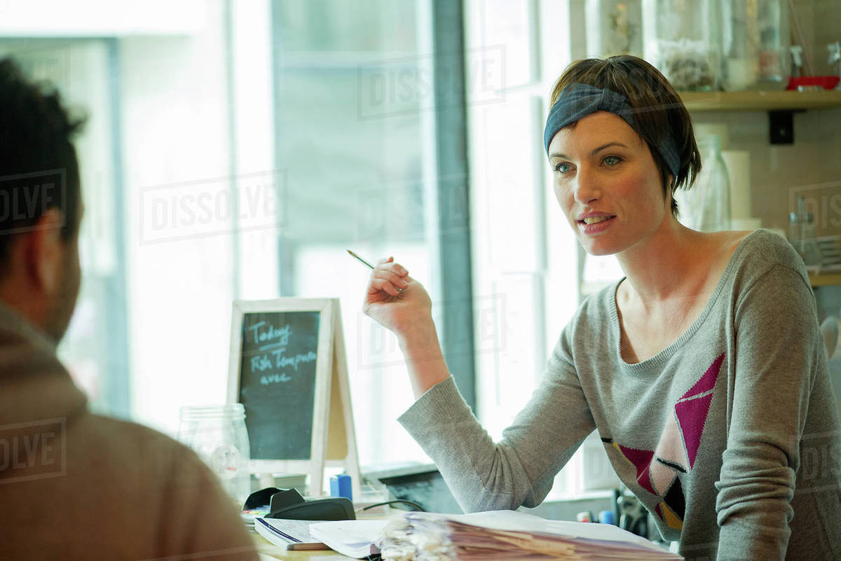 Waitress assisting customer in cafe - Royalty-free Stock Photo | Dissolve