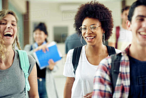 College students walking and laughing on campus - Stock Photo - Dissolve