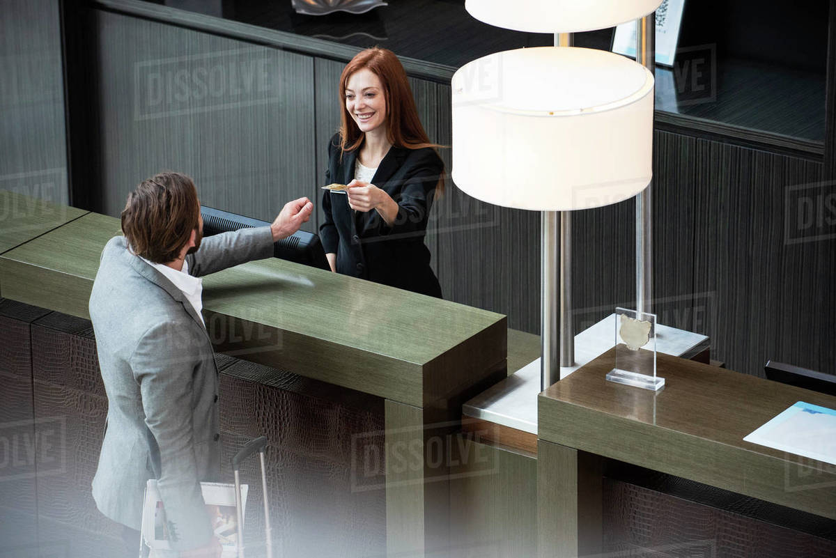 Female receptionist giving credit card to businessman - Stock Photo ...