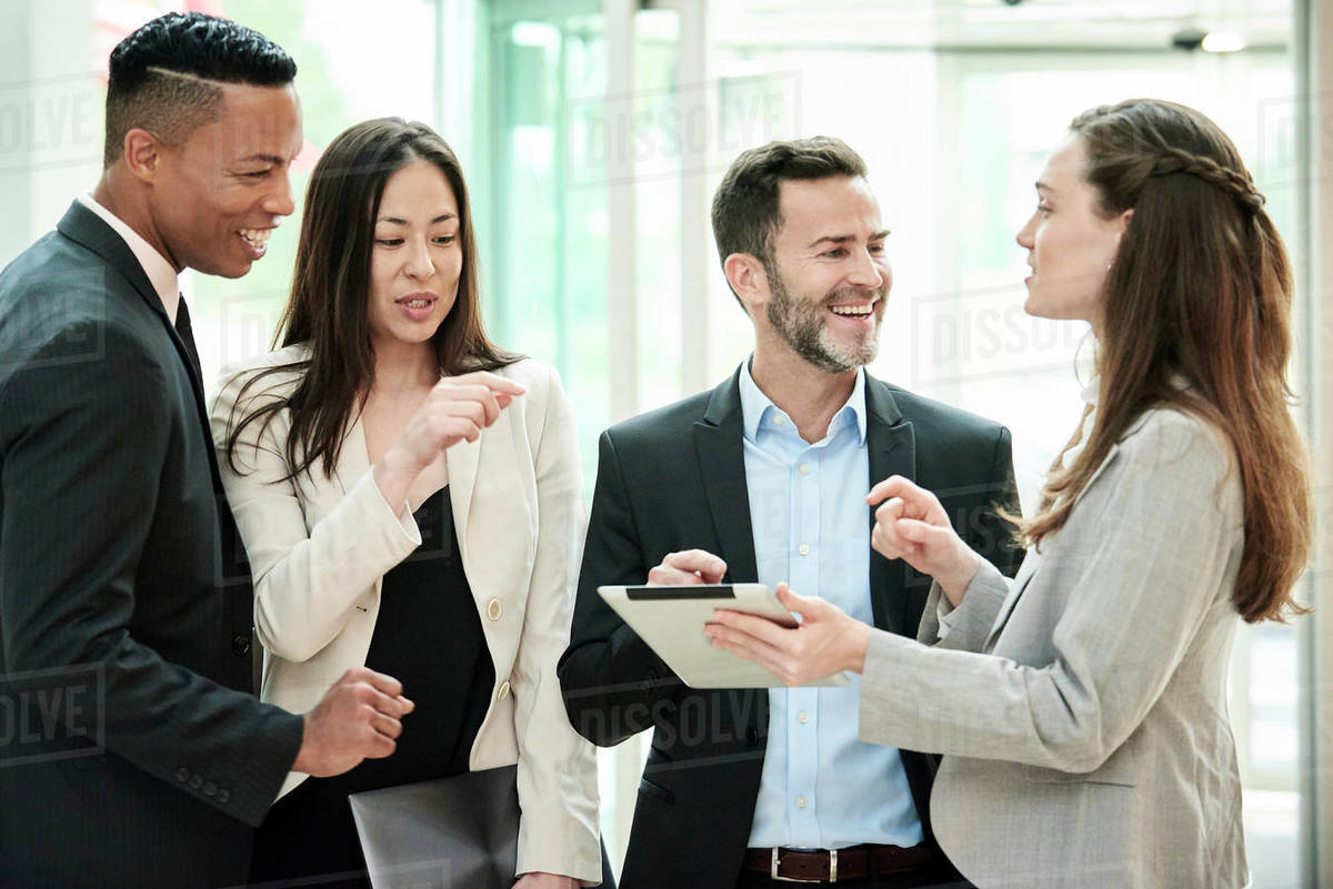 Business people standing and discussing in the hotel lobby - Royalty ...