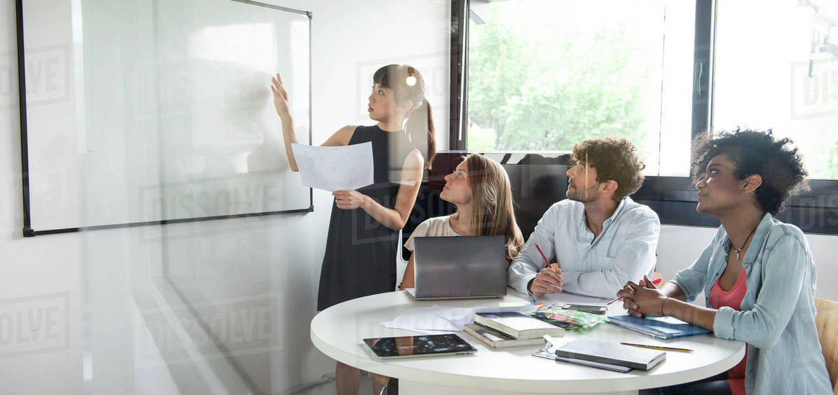 Businesswoman giving presentation in office - Stock Photo - Dissolve