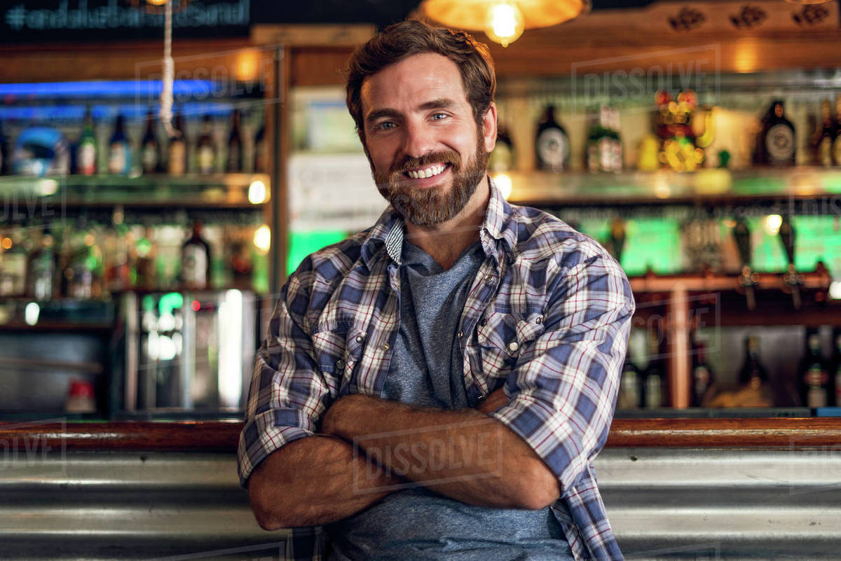 Portrait of smiling man leaning against bar counter - Royalty-free ...