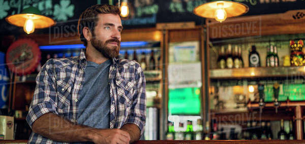 Man leaning against bar counter - Royalty-free Stock Photo | Dissolve