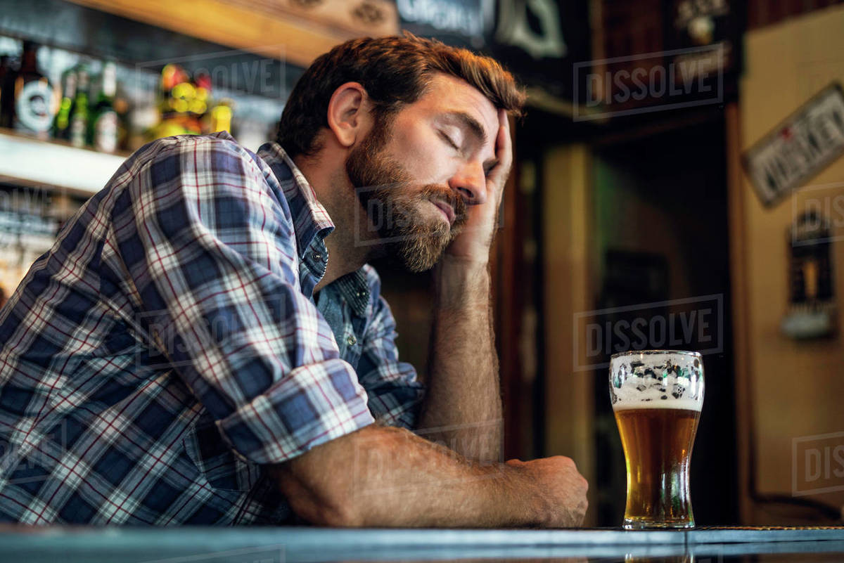 Sad man sitting in beer bar - Royalty-free Stock Photo | Dissolve