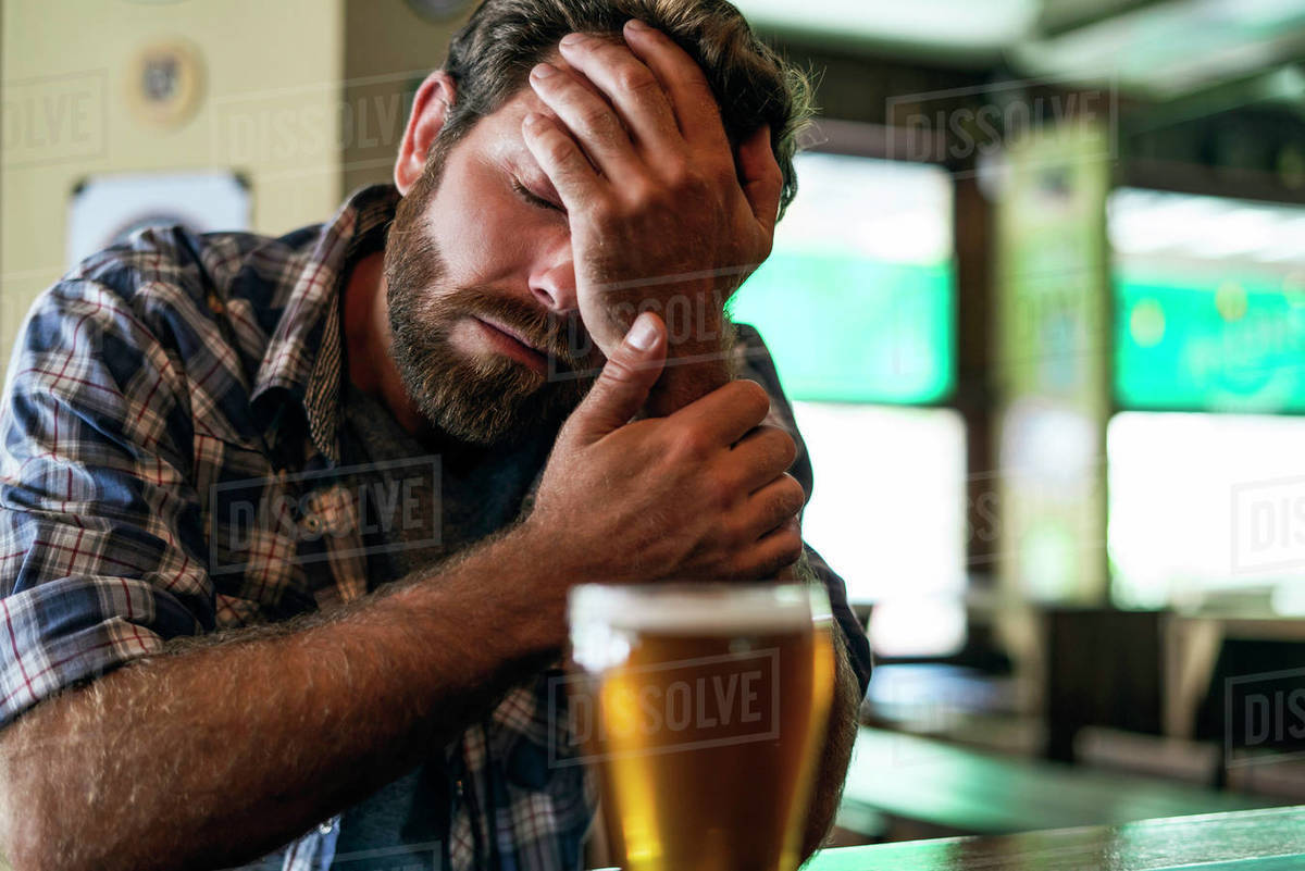 Sad man sitting in bar - Royalty-free Stock Photo | Dissolve