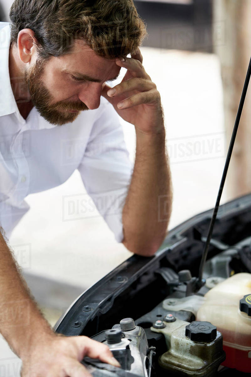 Man looking at car engine - Royalty-free Stock Photo | Dissolve