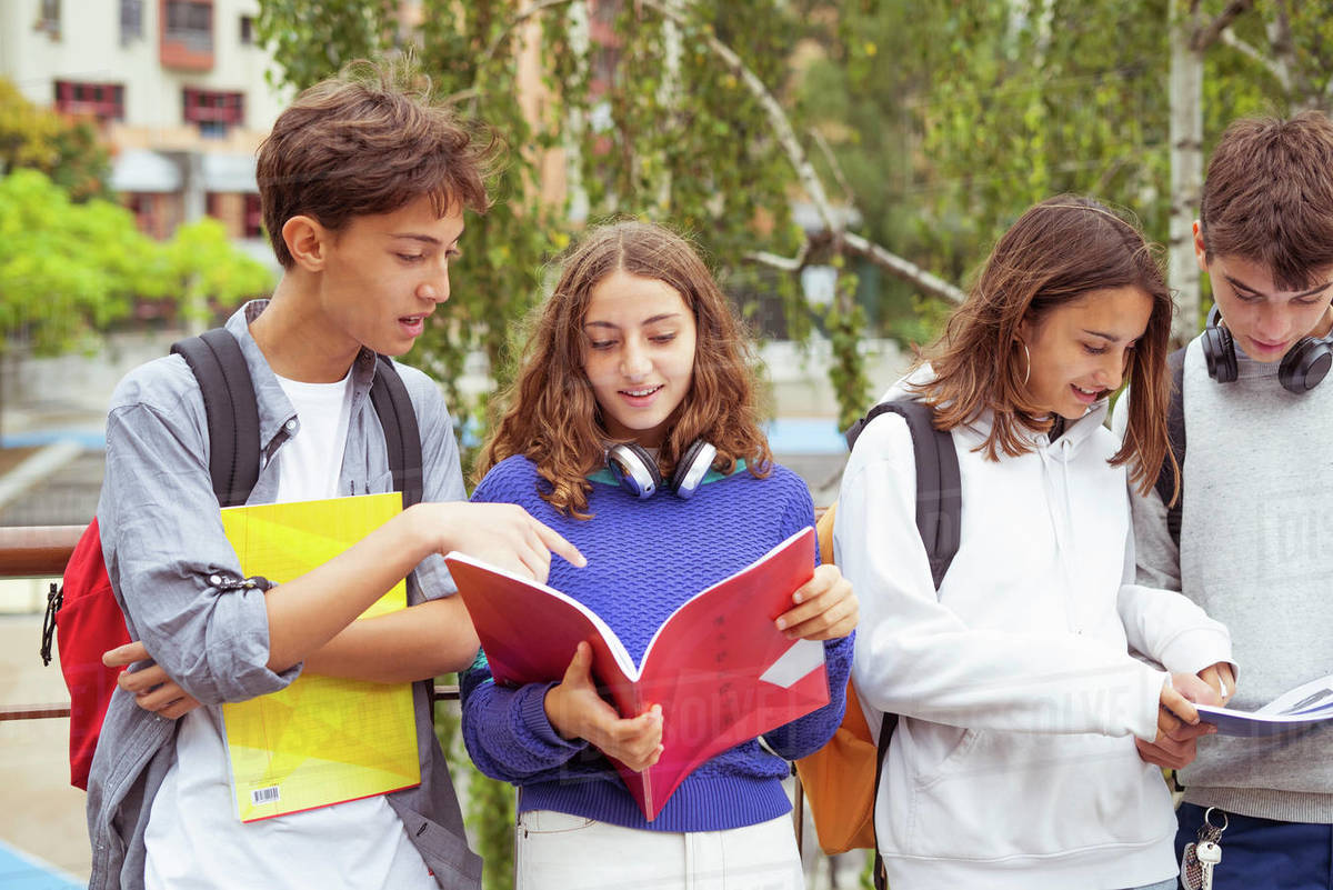Friends reading books outdoors - Royalty-free Stock Photo | Dissolve