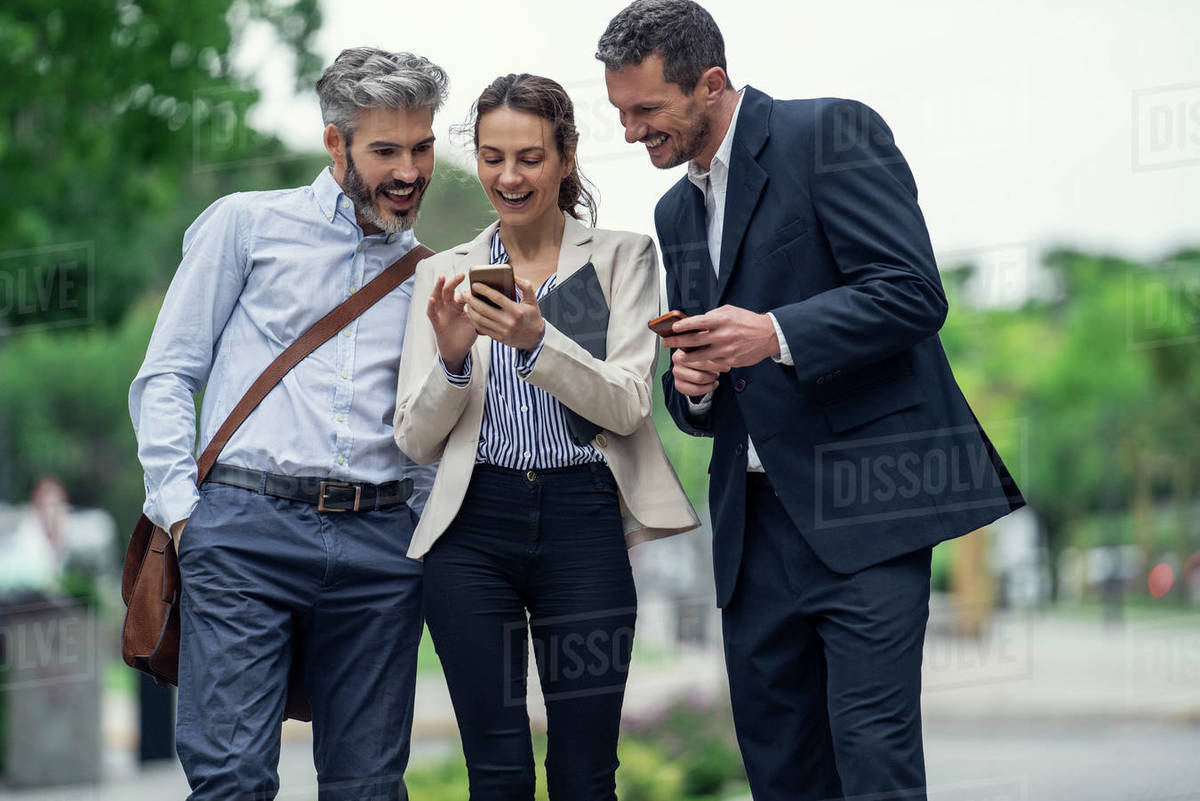 Business people using smartphones in public park - Royalty-free Stock ...