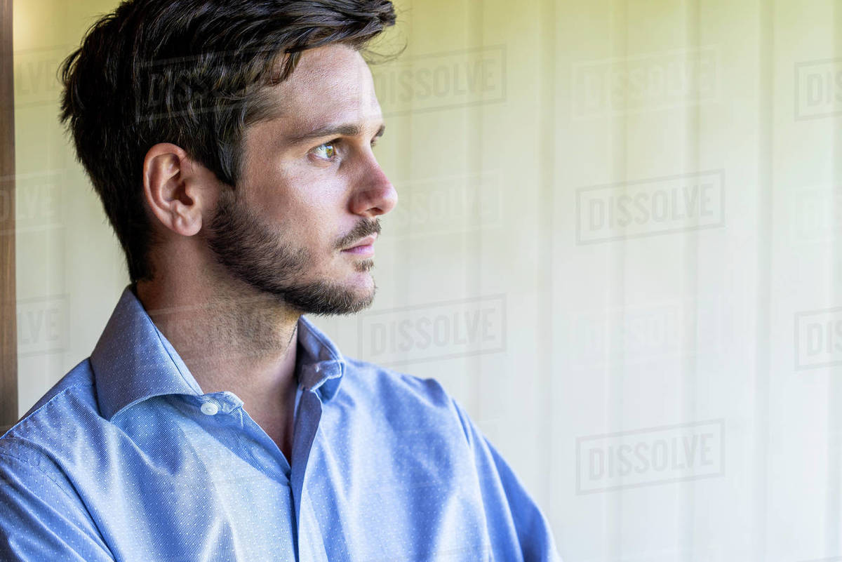 Portrait of young man standing in house - Royalty-free Stock Photo ...