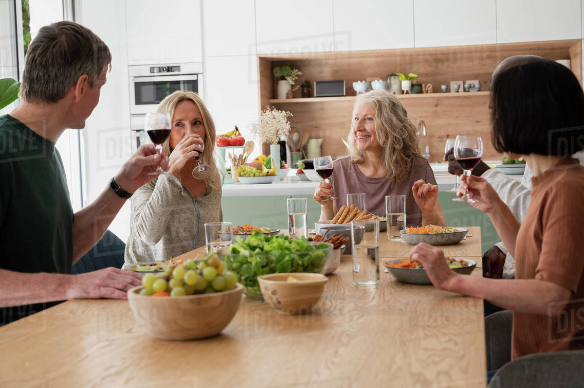 Diverse group of middle-aged friends having together at home - Royalty ...