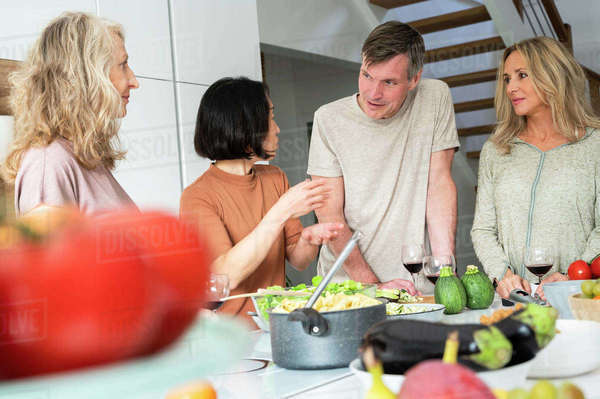 Senior Asian-American woman explaininghow to preapre a meal to group ...