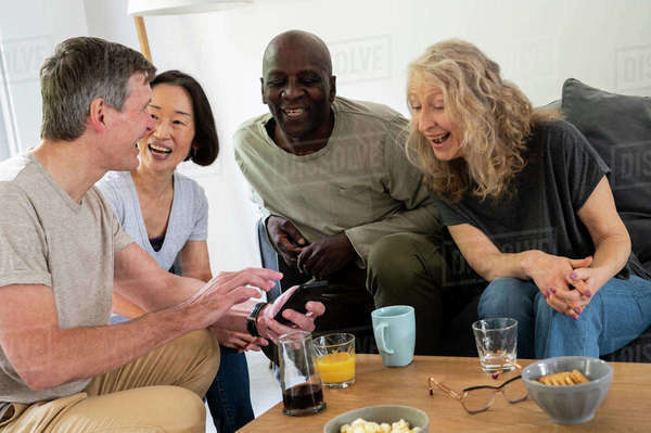 Group of diverse middle age friends having a good time at home ...