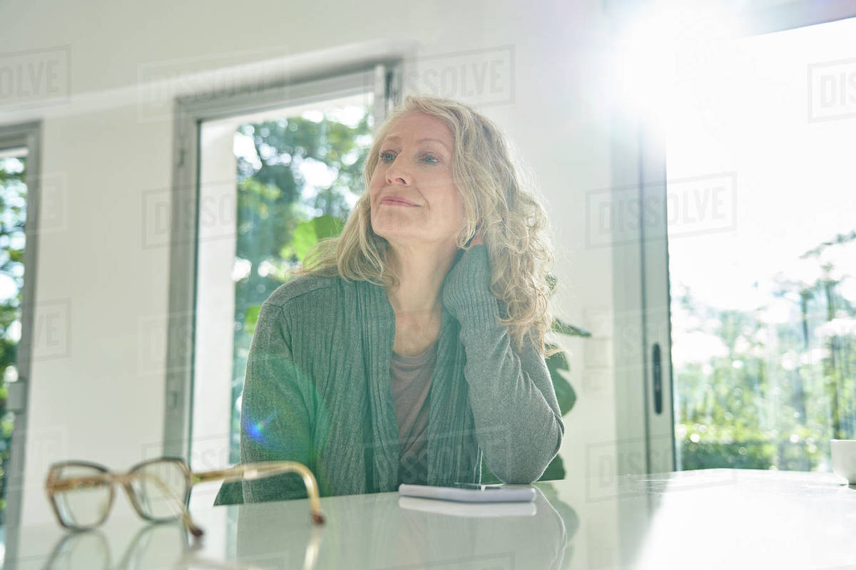 Thoughtful senior woman sitting at counter during daytime - Stock Photo ...
