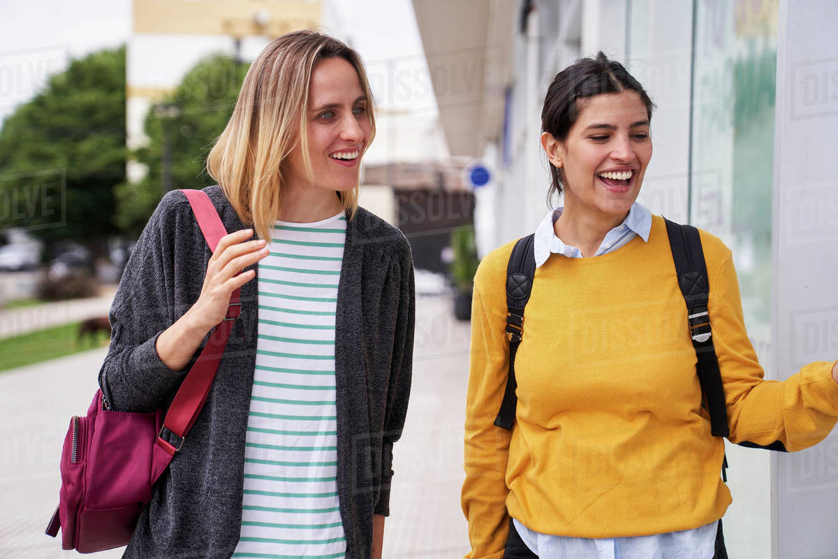 Photo of two friends window shopping outdoors - Stock Photo - Dissolve