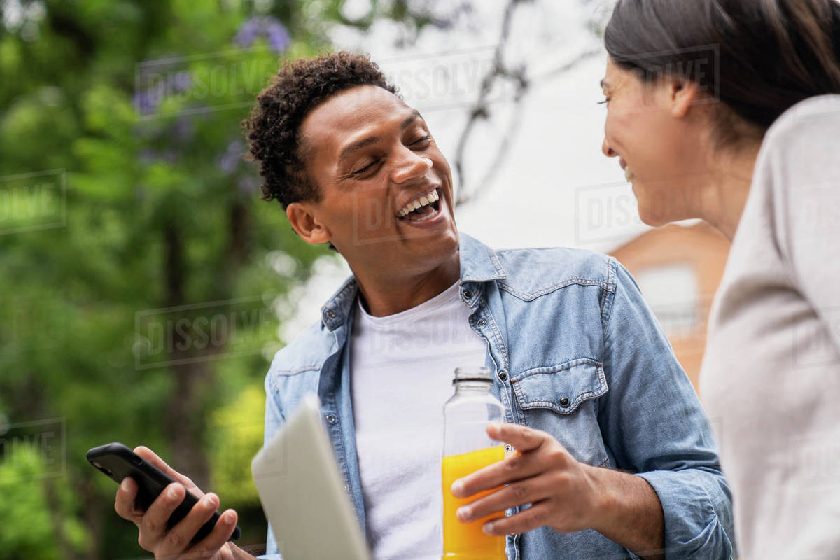 Low angle side shot of an ethnically diverse couple laughing while ...