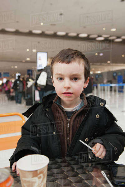 Boy taking break at cafe table - Royalty-free Stock Photo | Dissolve