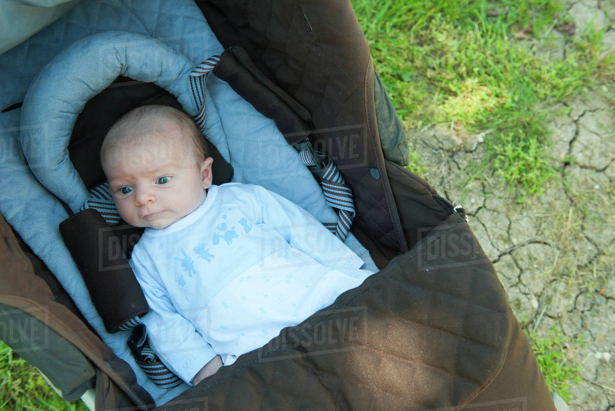 Baby in baby carriage outdoors - Stock Photo - Dissolve