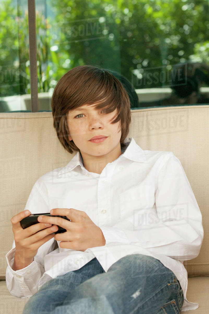 Teenage boy using cell phone - Stock Photo - Dissolve