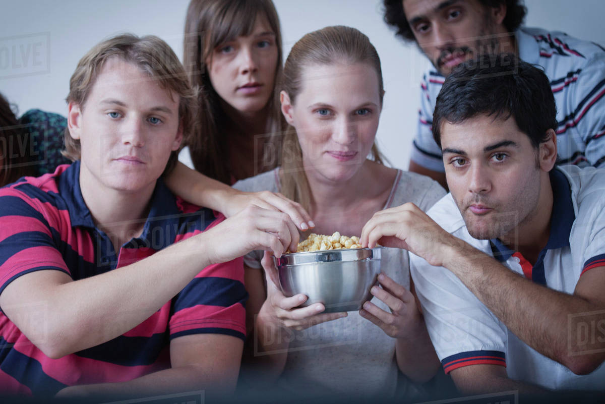 Friends sharing popcorn and watching movie together - Stock Photo ...