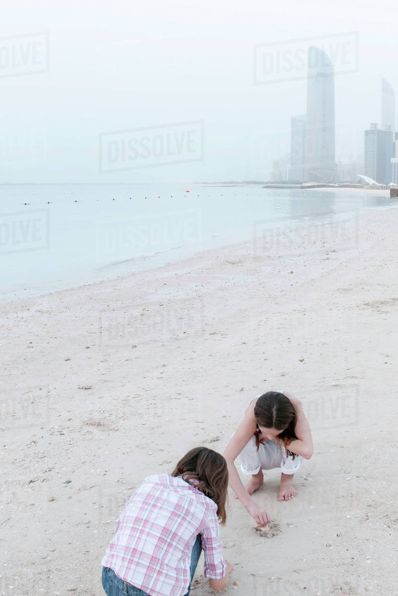 Girls looking for seashells at the beach - Royalty-free Stock Photo ...