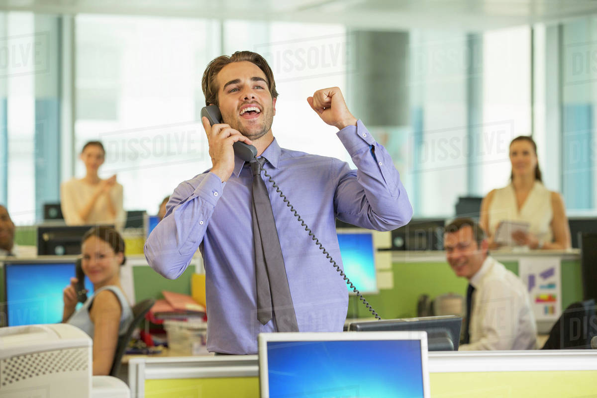 Businessman cheering in office - Stock Photo - Dissolve
