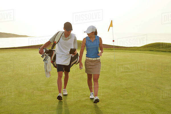 Golfer and caddy walking on golf course - Royalty-free Stock Photo ...