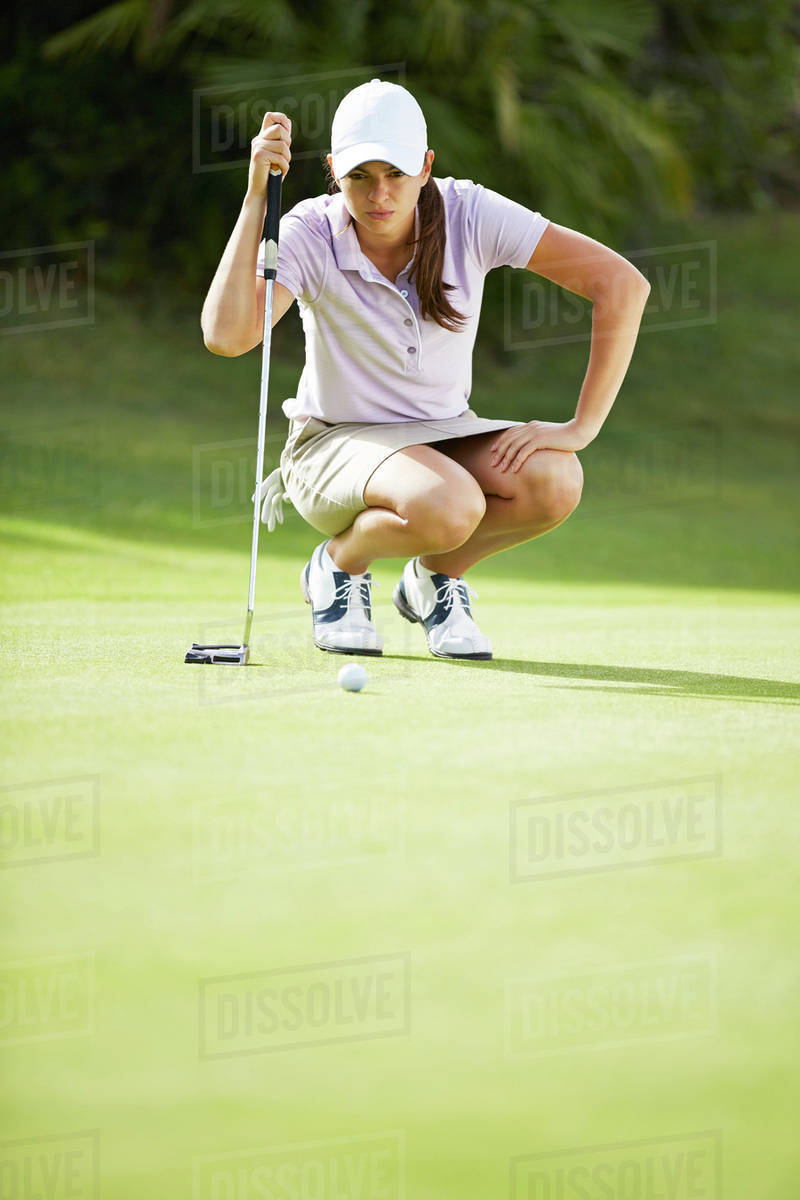 Woman preparing to putt on golf course - Royalty-free Stock Photo ...
