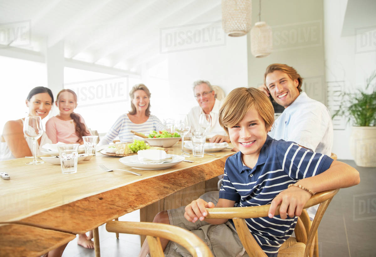 Family smiling together at table - Royalty-free Stock Photo | Dissolve