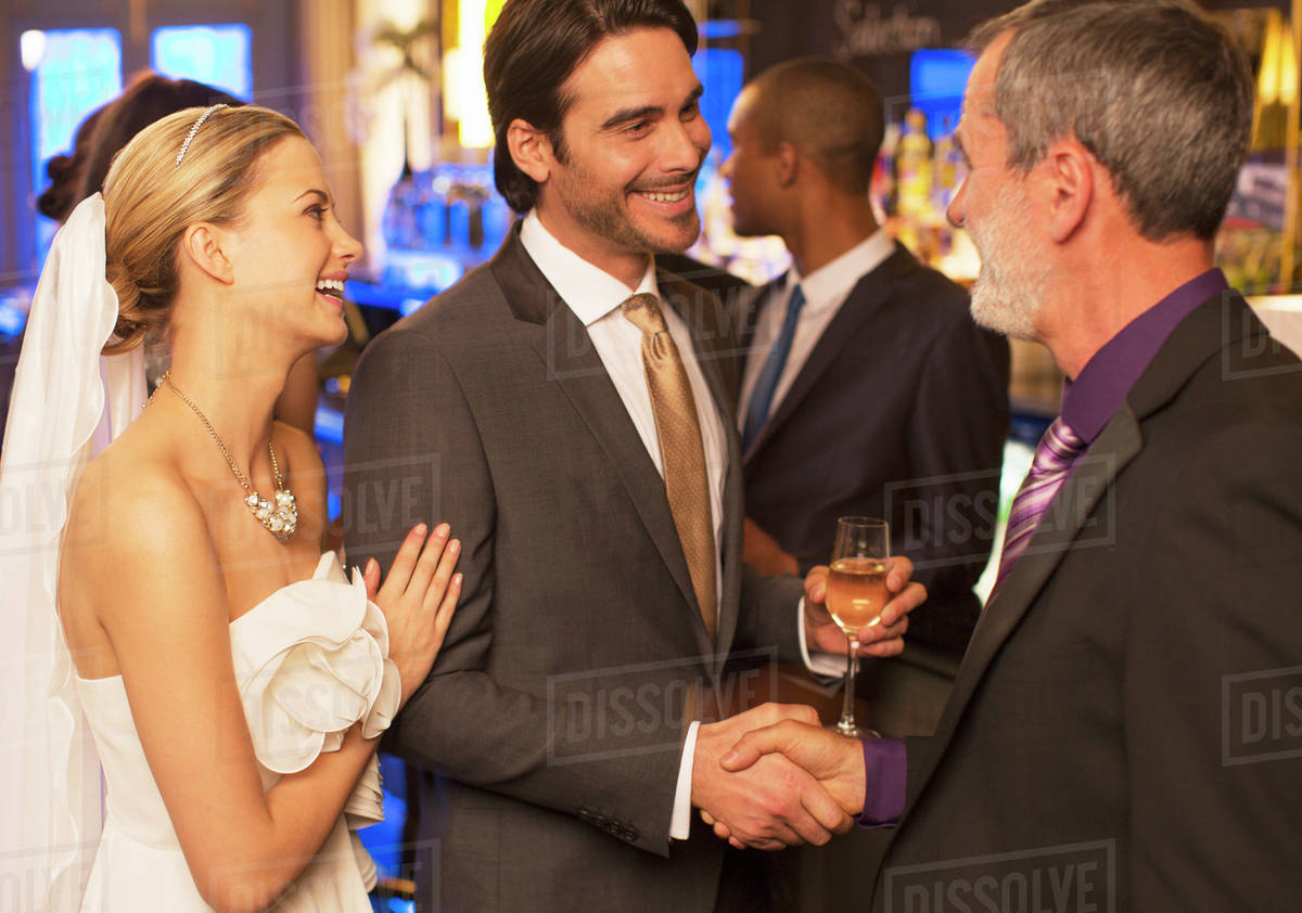 Man shaking hands with groom at wedding reception - Royalty-free Stock ...