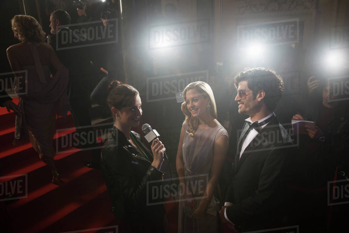 Celebrity couple being interviewed on red carpet - Stock Photo - Dissolve