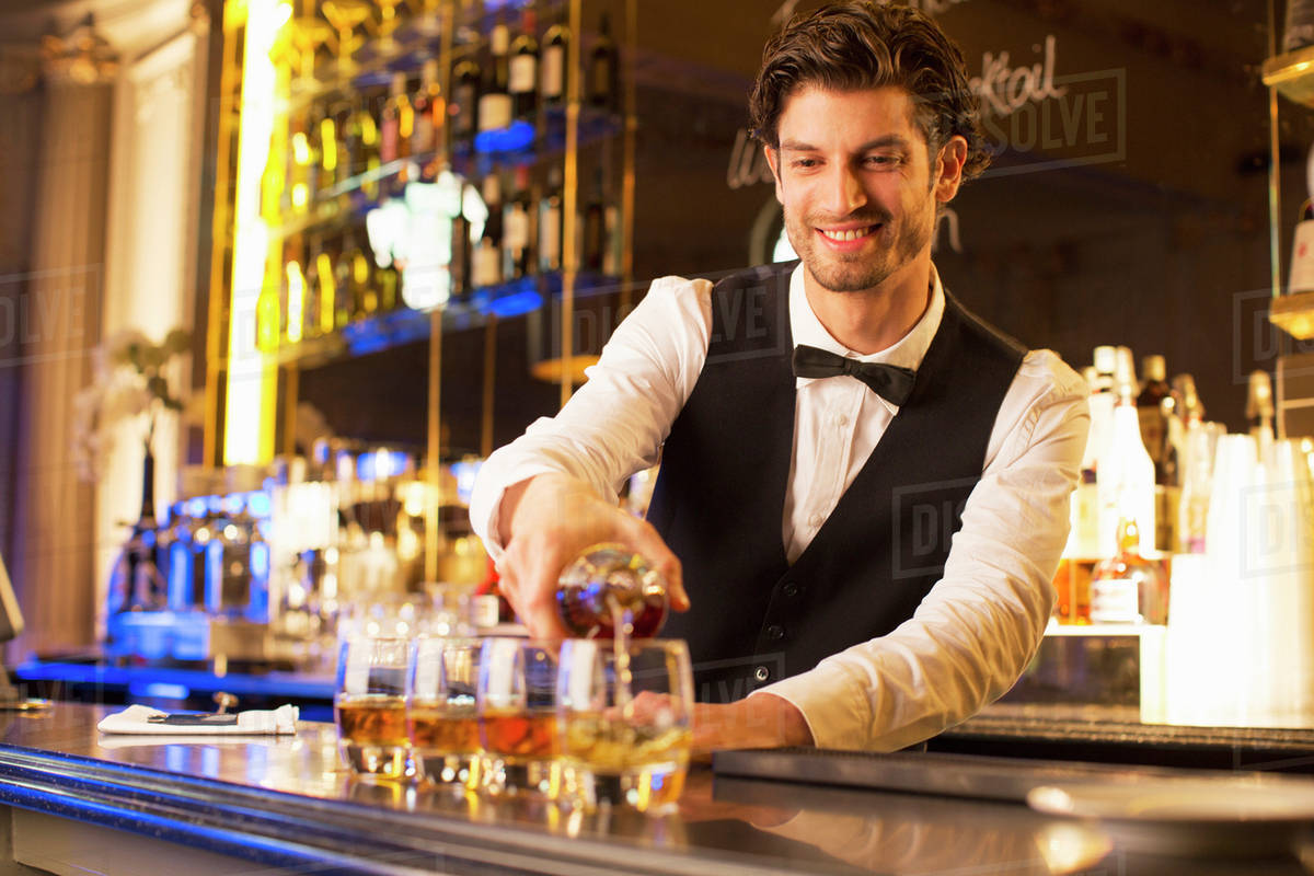 Well dressed bartender pouring bourbon at luxury bar - Royalty-free ...