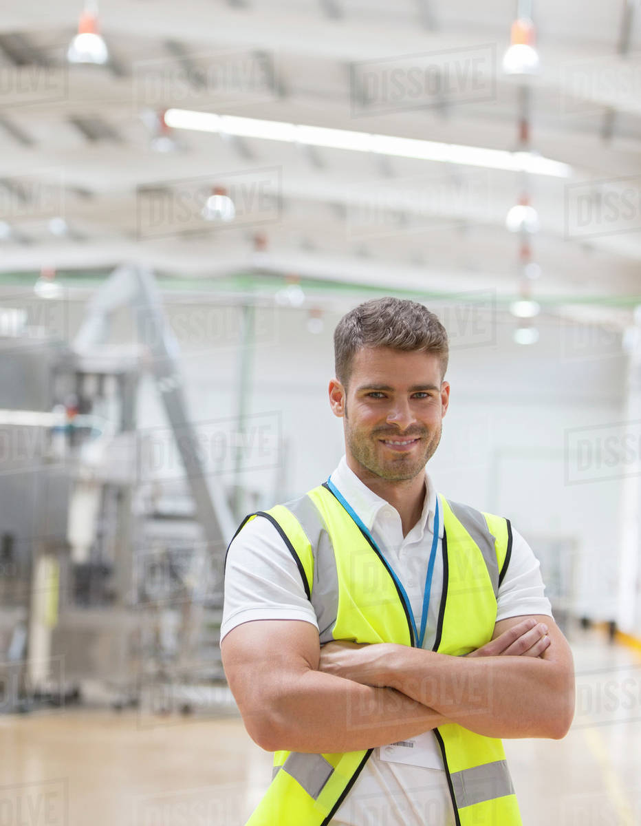 Worker smiling in factory - Royalty-free Stock Photo | Dissolve