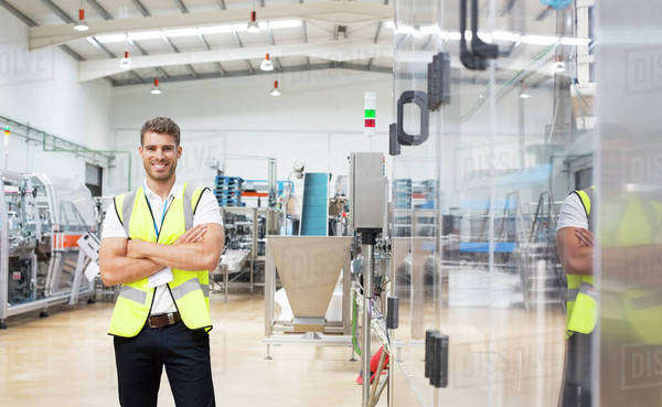 Worker smiling in factory - Stock Photo - Dissolve
