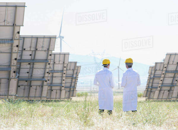 Scientists standing by solar panels in rural landscape - Stock Photo ...