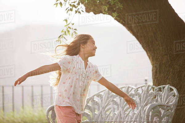 Girl running with arms outstretched - Stock Photo - Dissolve