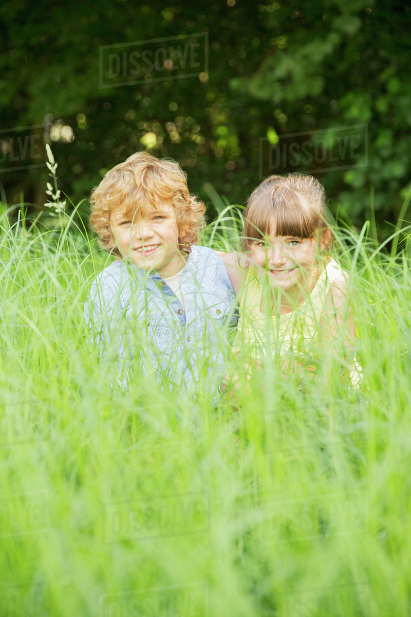 Children playing in tall grass - Royalty-free Stock Photo | Dissolve