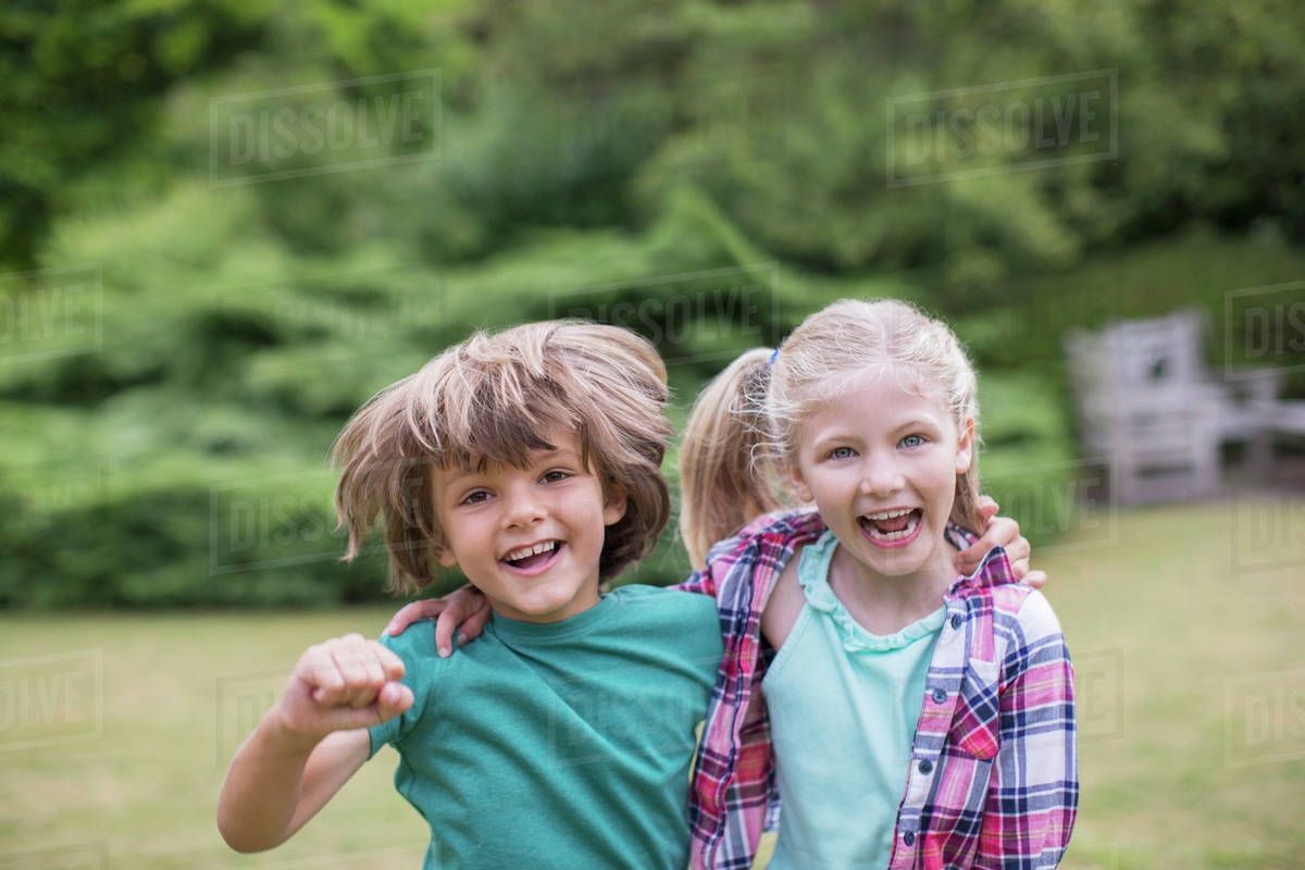 Smiling children hugging outdoors - Stock Photo - Dissolve