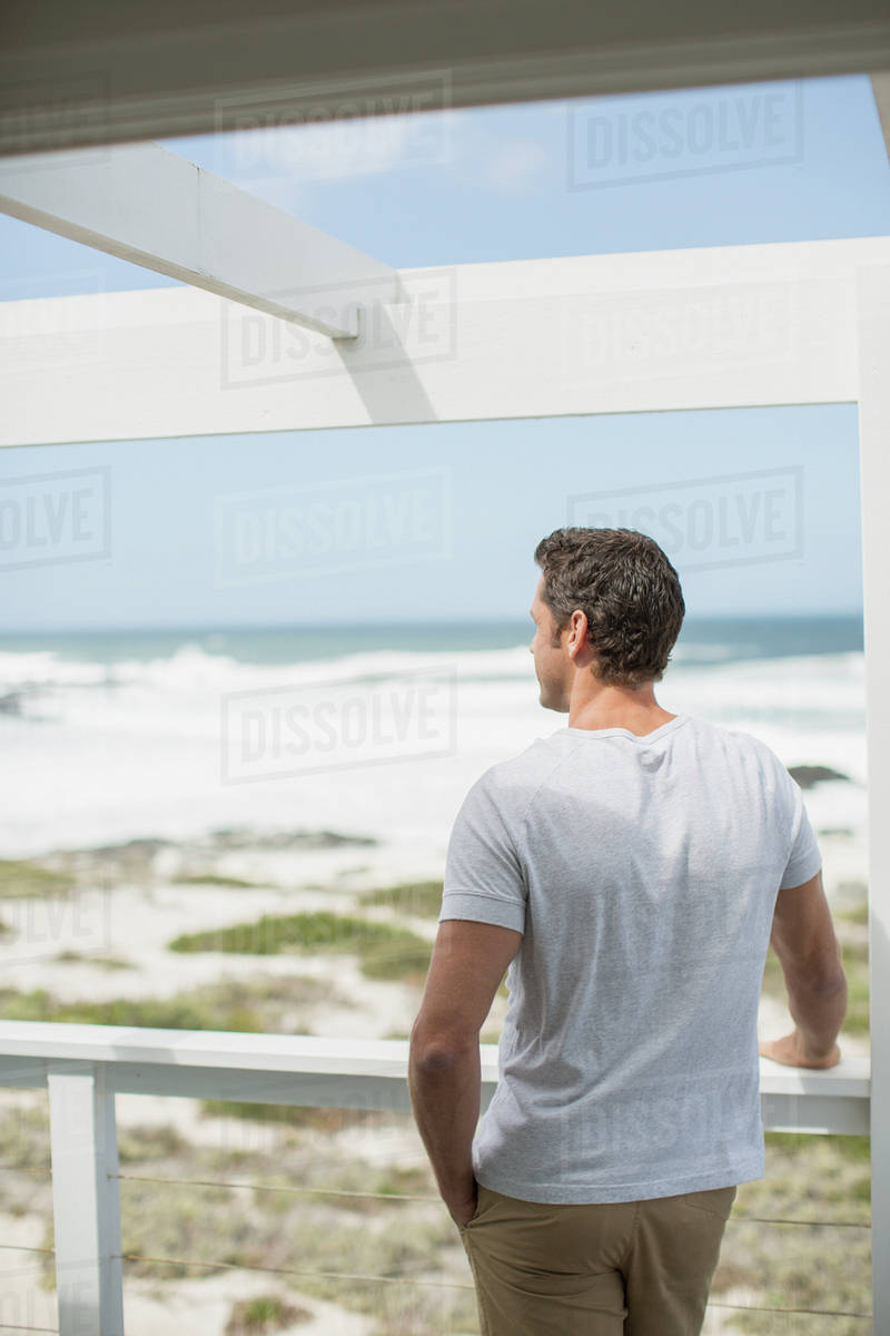 Man looking at ocean view from balcony - Royalty-free Stock Photo ...
